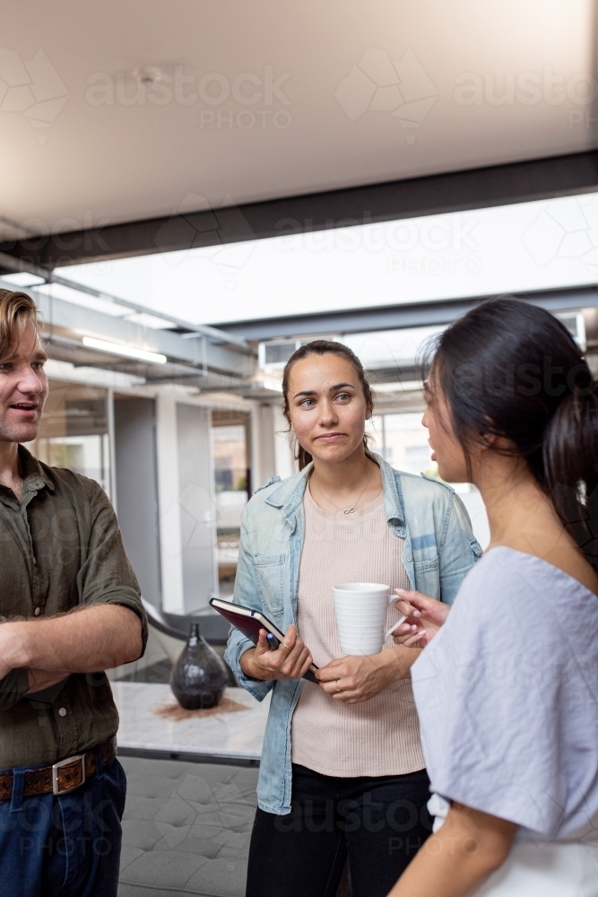Image of Office workers talking in the hallway in an office - Austockphoto