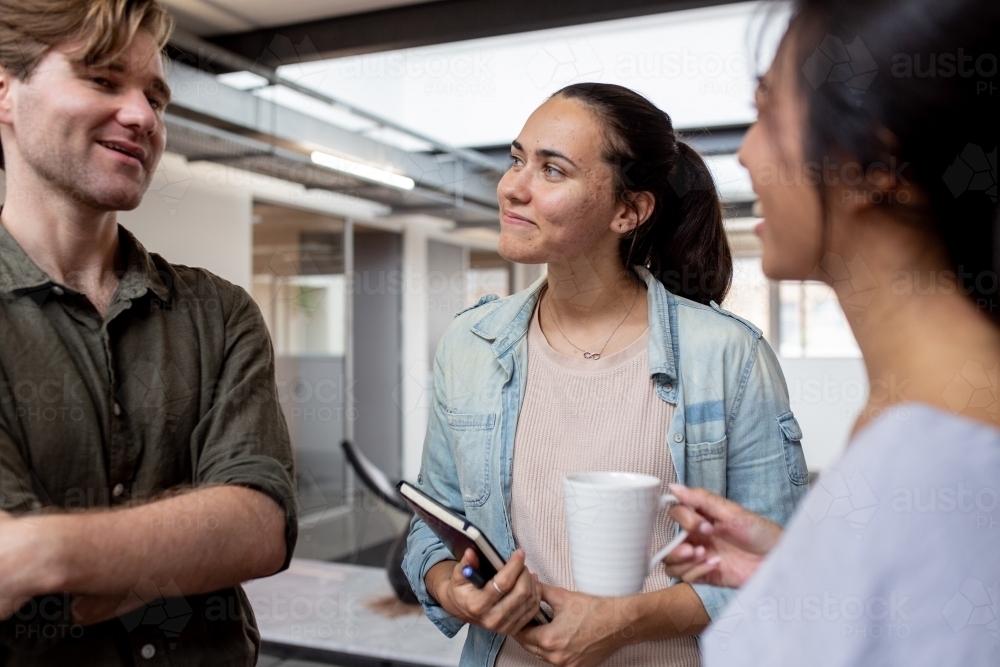 Image of Office workers talking in the hallway in an office - Austockphoto
