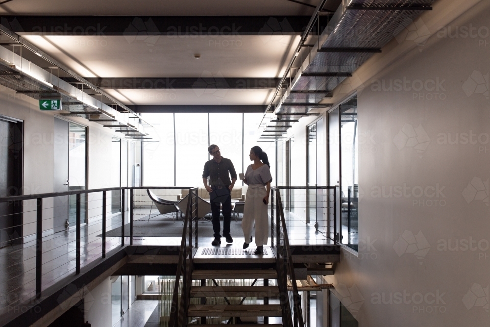 Image of Office workers walking down the stairs in an industrial space ...