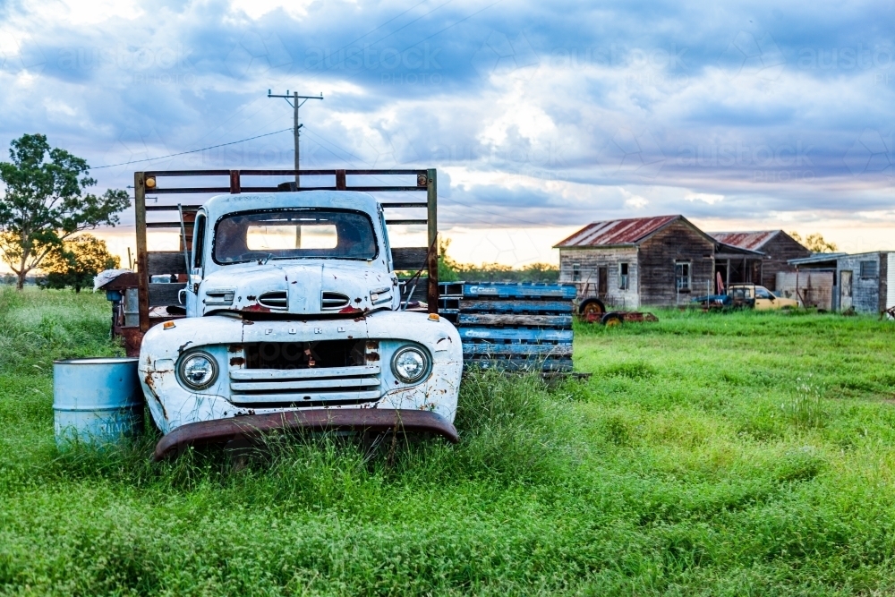 Image of old blue truck in green farm paddock - Austockphoto