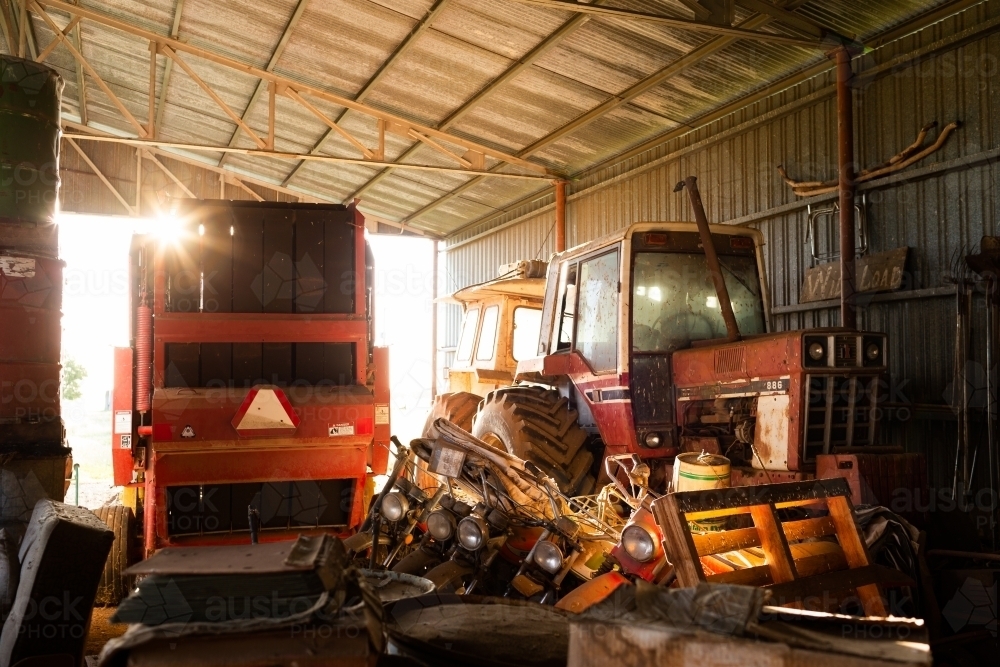 Image of Old farm machinery parked in dark shed left to rust and ...