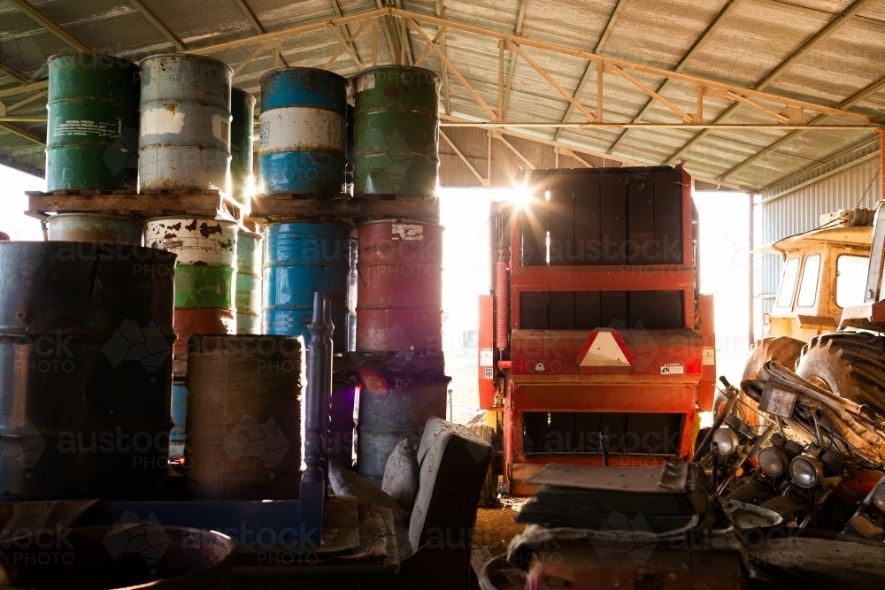 Image of Old farm machinery parked in dark shed left to rust and forgotten in time - Austockphoto
