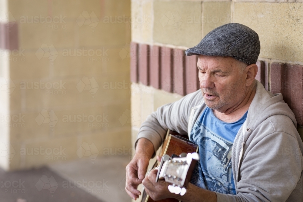Image of Old guy singing and playing guitar - Austockphoto