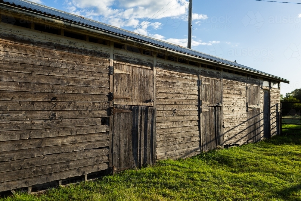 Image of Old weather worn structure of wooden stables on farm in ...