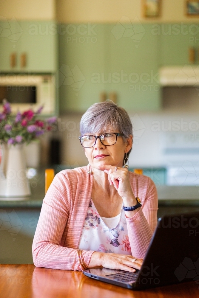 Image of Older woman struggling using laptop technology - Austockphoto
