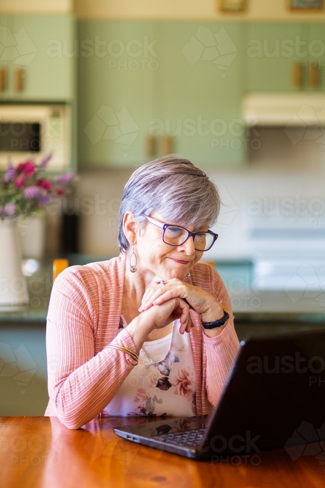 Image of Older woman struggling using laptop technology - Austockphoto