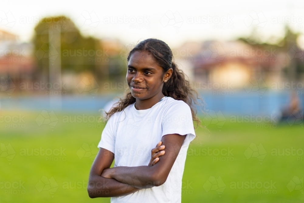 Image of one aboriginal girl standing with arms crossed with blurry ...