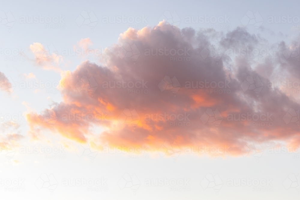 Image of one cloud floating in the sky at sunset - Austockphoto