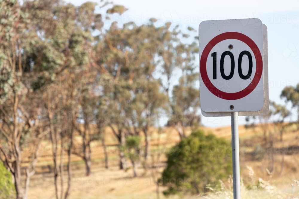 Image of One hundred kilometer speed sign by a rural road - Austockphoto