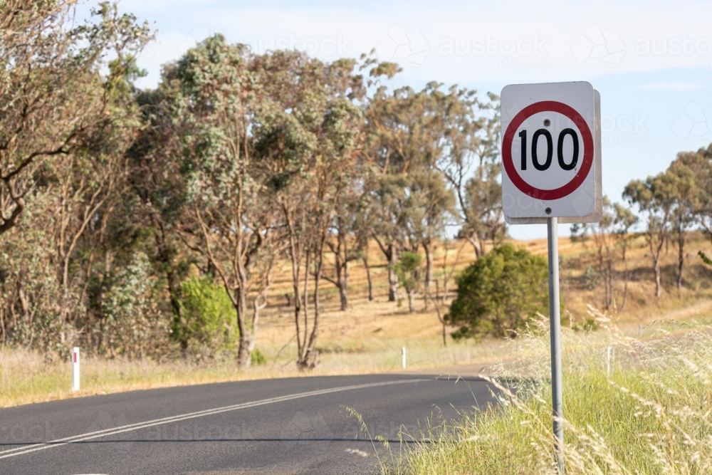 Image of One hundred kilometer speed sign by a rural road - Austockphoto
