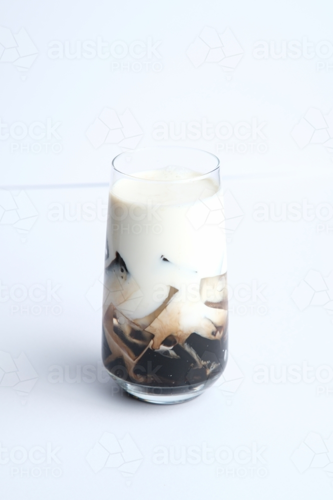 Image of One refreshing ice-cold drink in a tall glass on a white ...