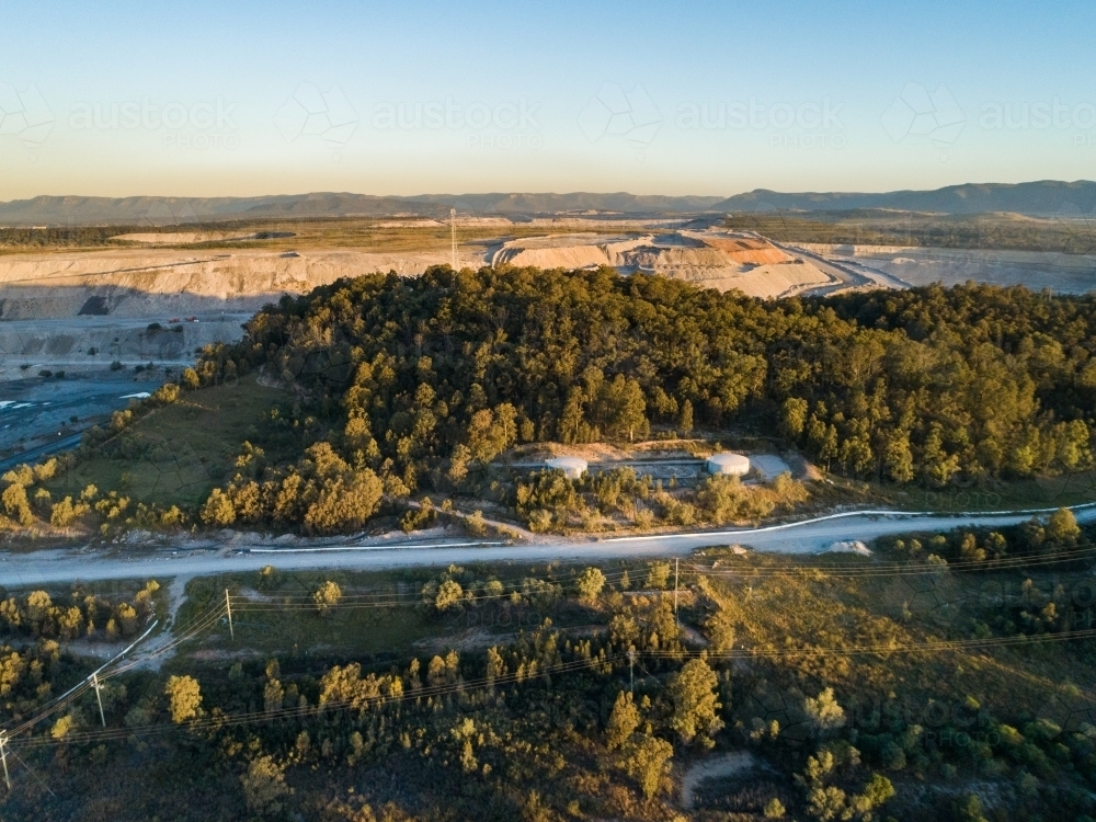 Image of Open cut coal mine behind hill seen from aerial view ...