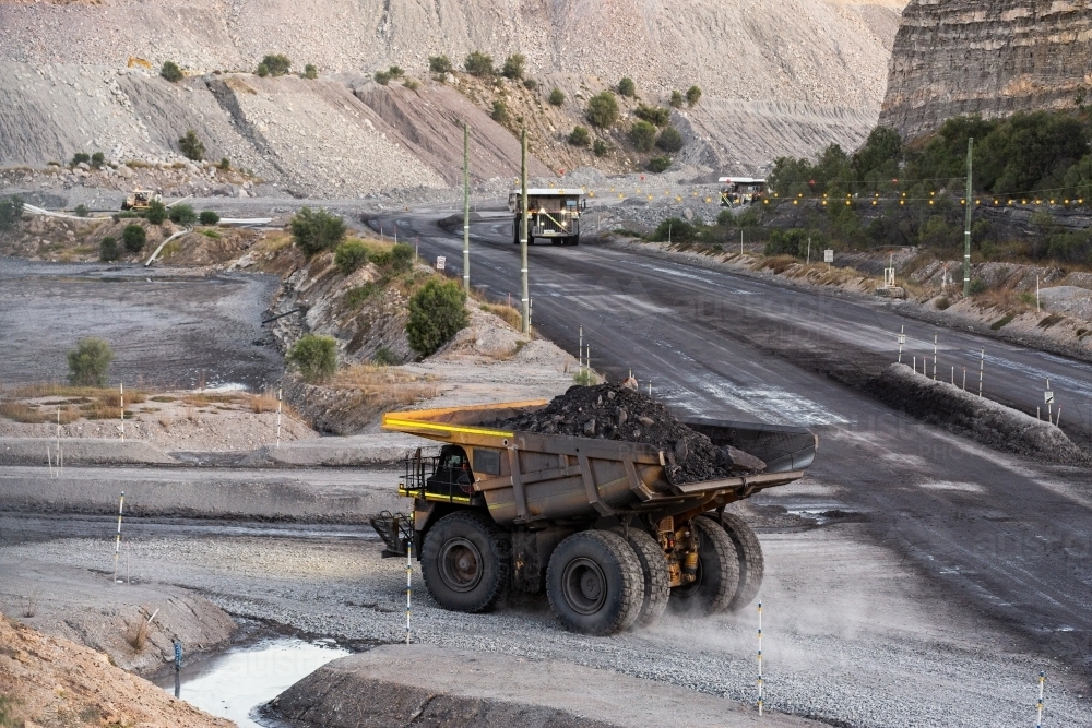 Image of Open cut coal mine site with big machinery working - Austockphoto