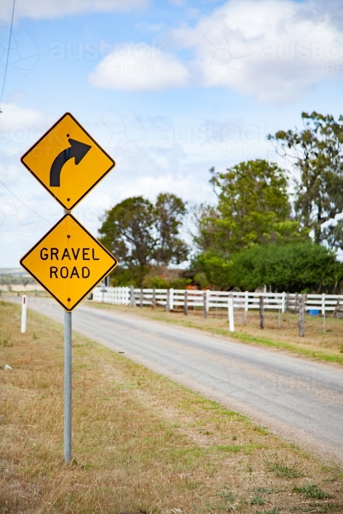 Image of Orange road sign for bend and gravel road in the country ...