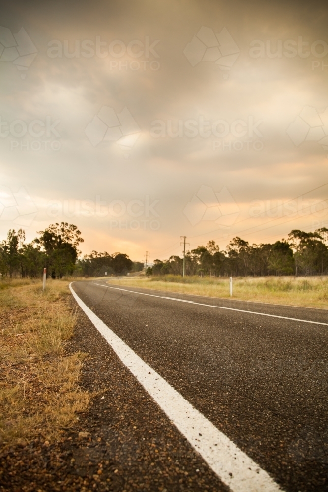 Image of Orange smokey sky from bushfire above road - Austockphoto