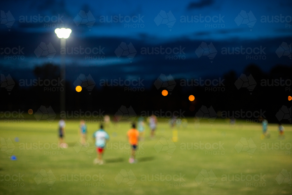 Image of out of focus night time kids cricket practice - Austockphoto