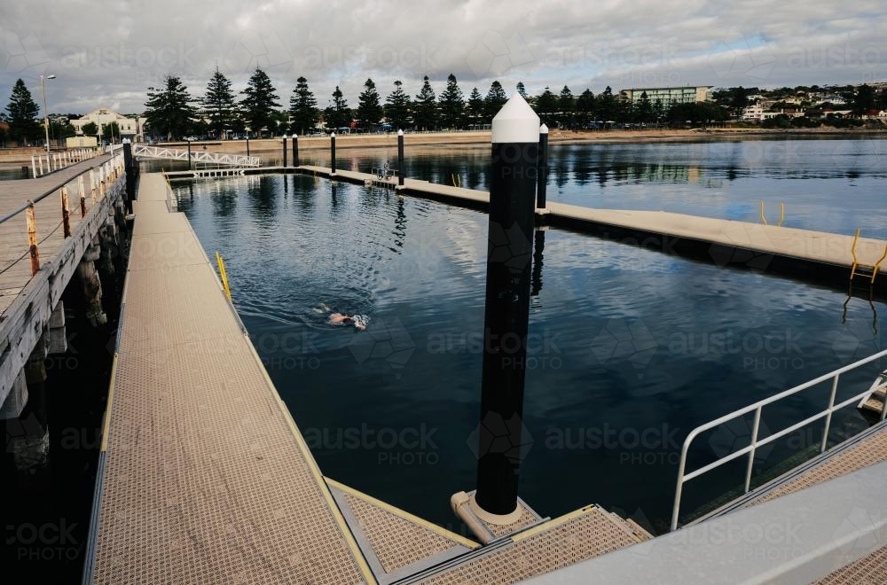 Image of outdoor sea pool with one anonymous swimmer - Austockphoto