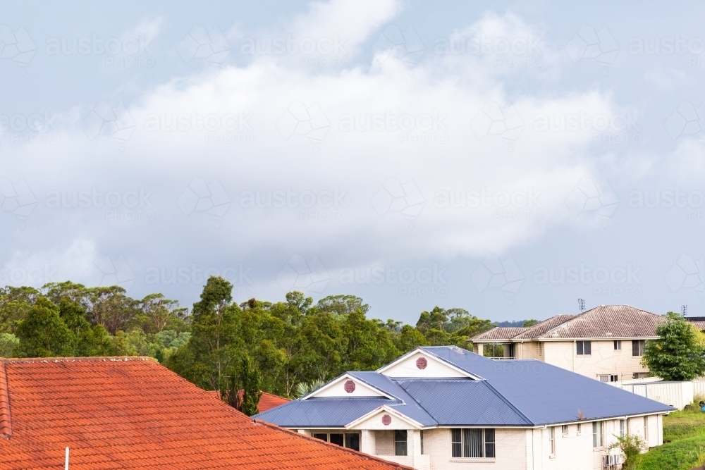 Image of Overcast cloudy sky above rooves - Austockphoto