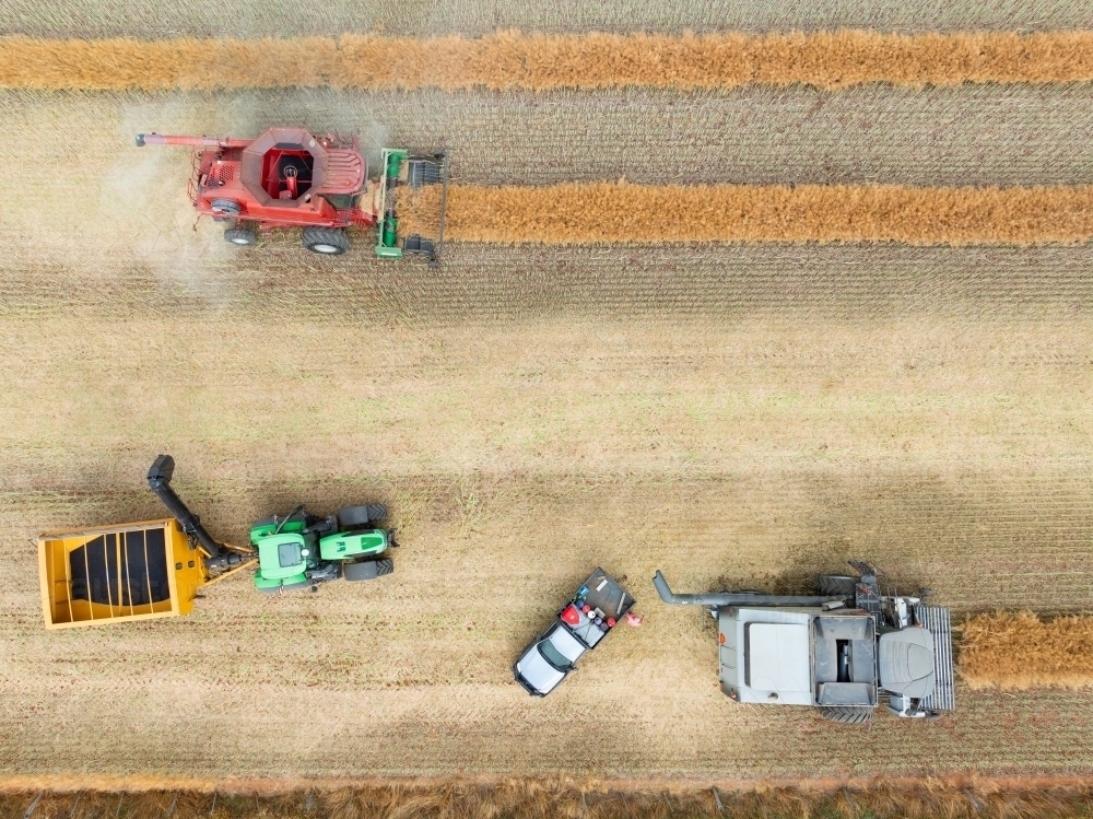 Image of overhead aerial view of a harvester and farm machinery working ...