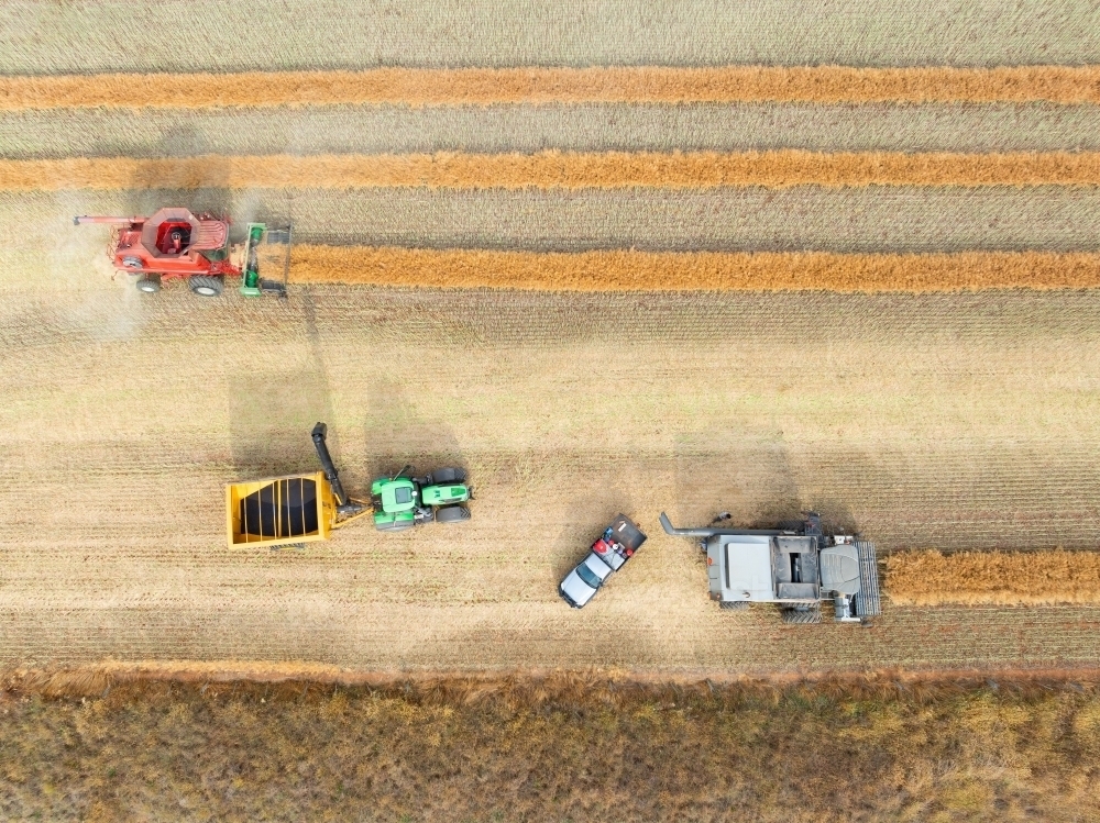Image of overhead aerial view of a harvester and farm machinery working ...