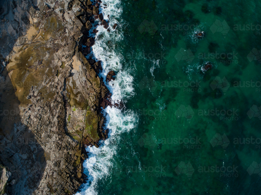 Image of Overhead coastal view of ocean waves crashing onto rocks on ...