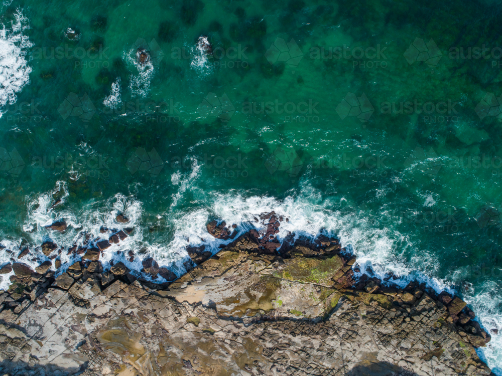 Image of Overhead coastal view of ocean waves crashing onto rocks on ...
