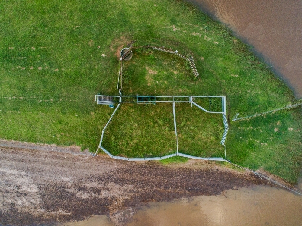Image of Overhead shot of cattle yards on a farm with floodwaters ...