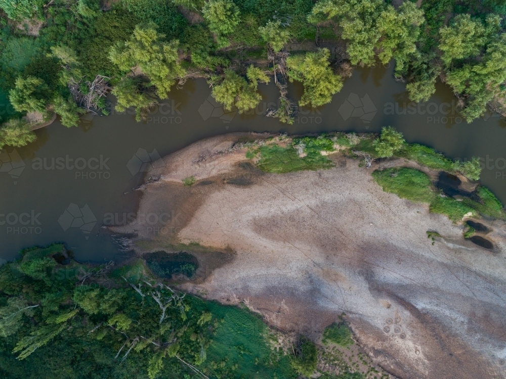 Image of Overhead view of mudbank at the edge of river - Austockphoto