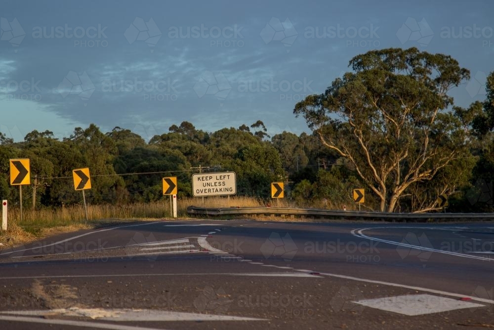 Image of Overtaking road signs on a curve - Austockphoto