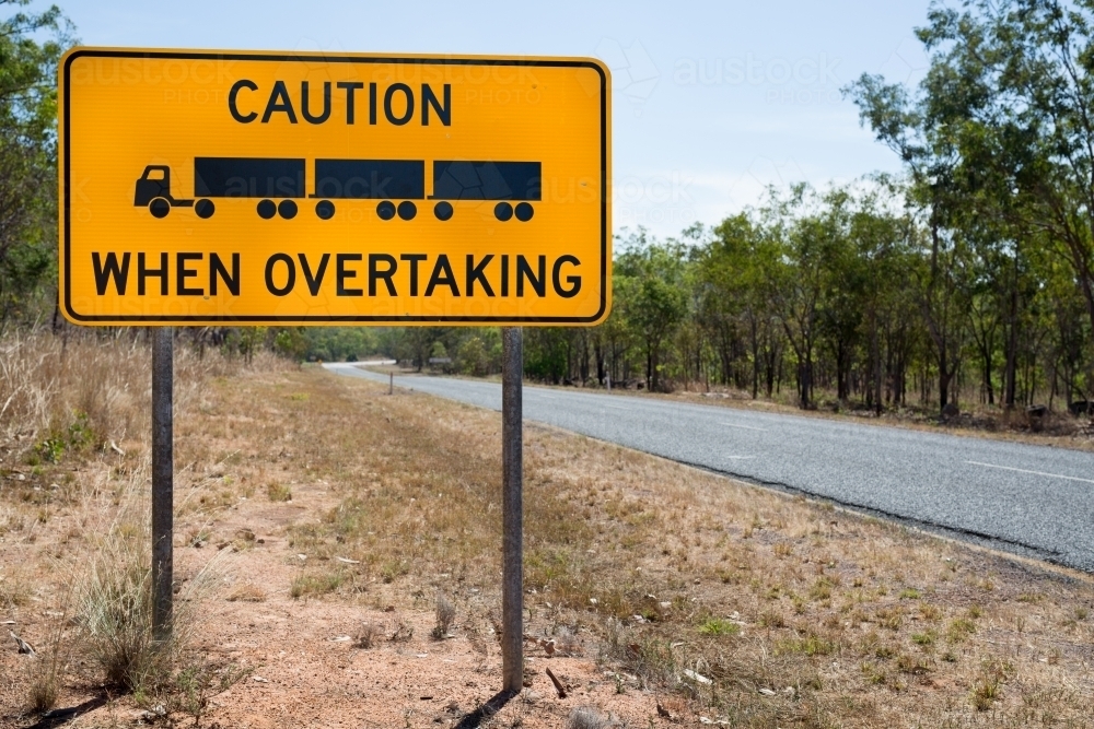 Image of Overtaking signage on an empty road - Austockphoto