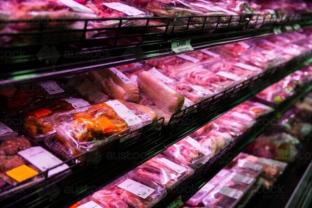 Image of packets of meat on refrigerated shelves in a butcher's shop ...