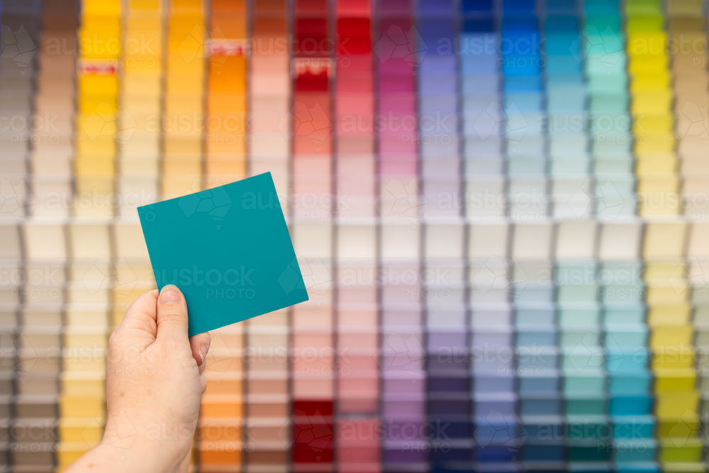 Image of paint sample colour held up in a hardware store - Austockphoto