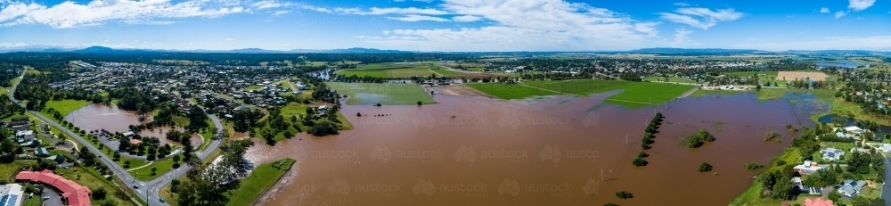 Image of panorama of brown floodwaters backflowing over farmland road ...