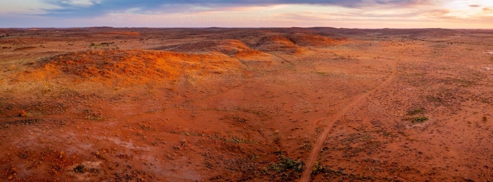 Image of Panoramic aerial view of tracks running though a barren orange ...