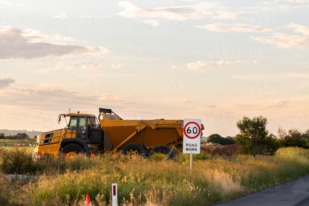 Image of pastel sky over dump truck beside road works 60 speed limit ...
