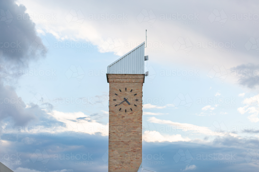 Image of Patch of blue sky in clouds behind clock tower in brick ...