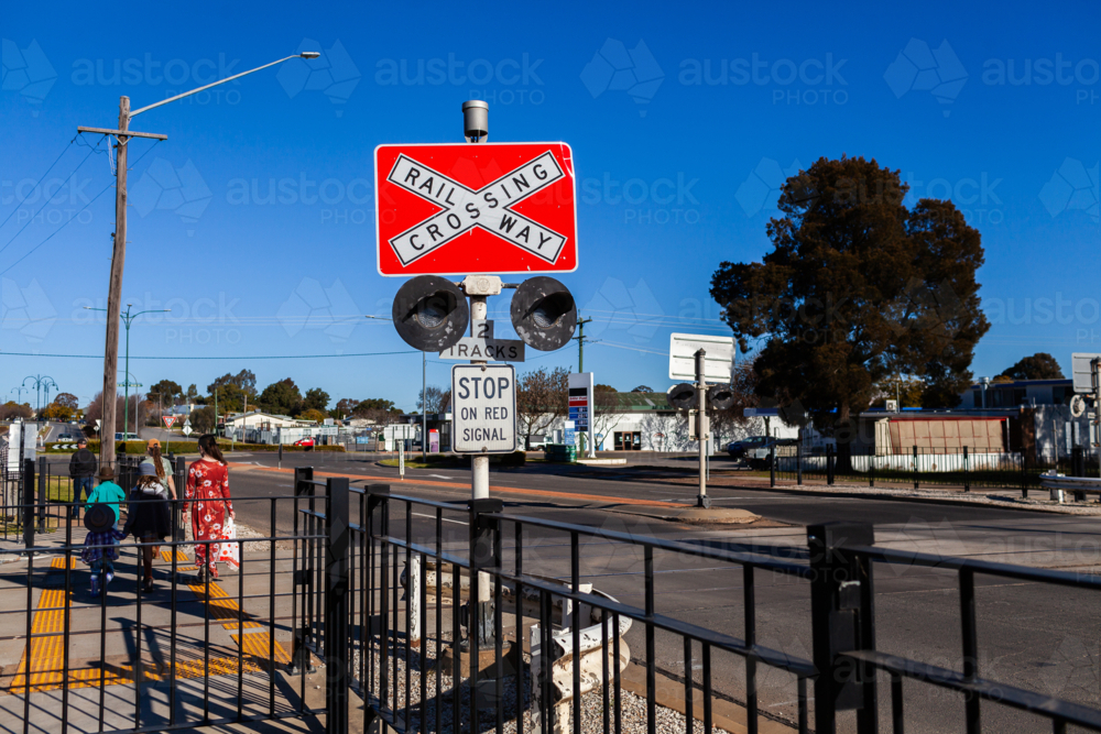 Image of people crossing railway tracks at sign in country town of ...