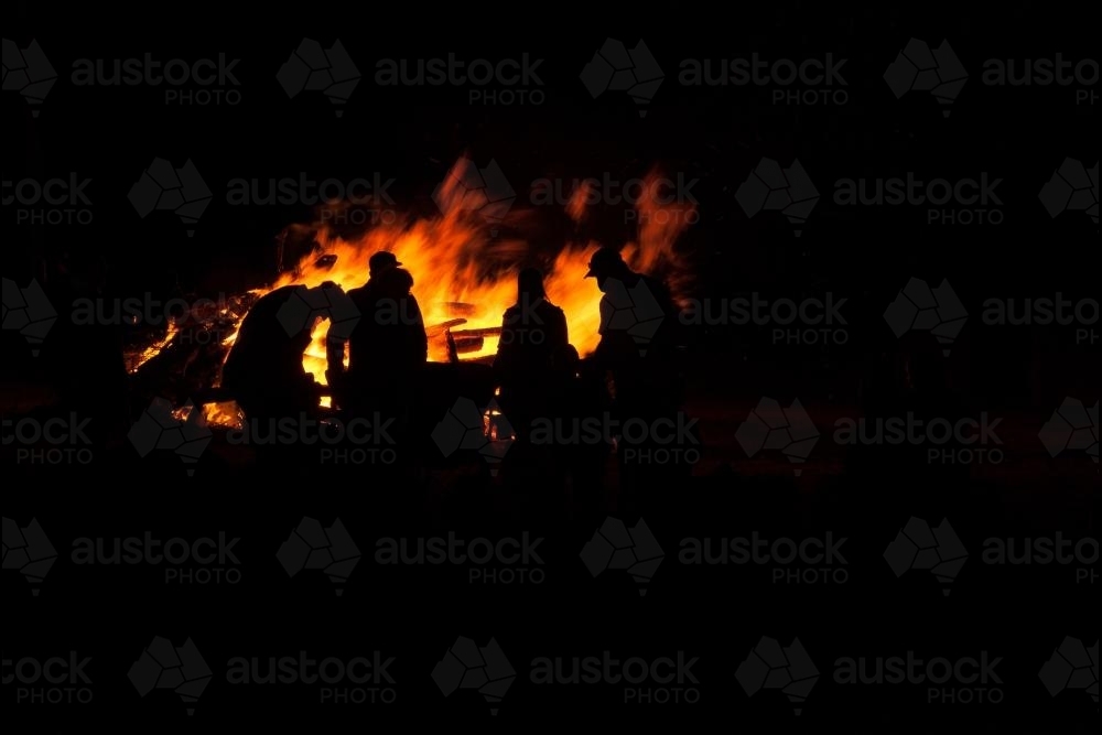 Image of People standing around the bonfire talking - Austockphoto