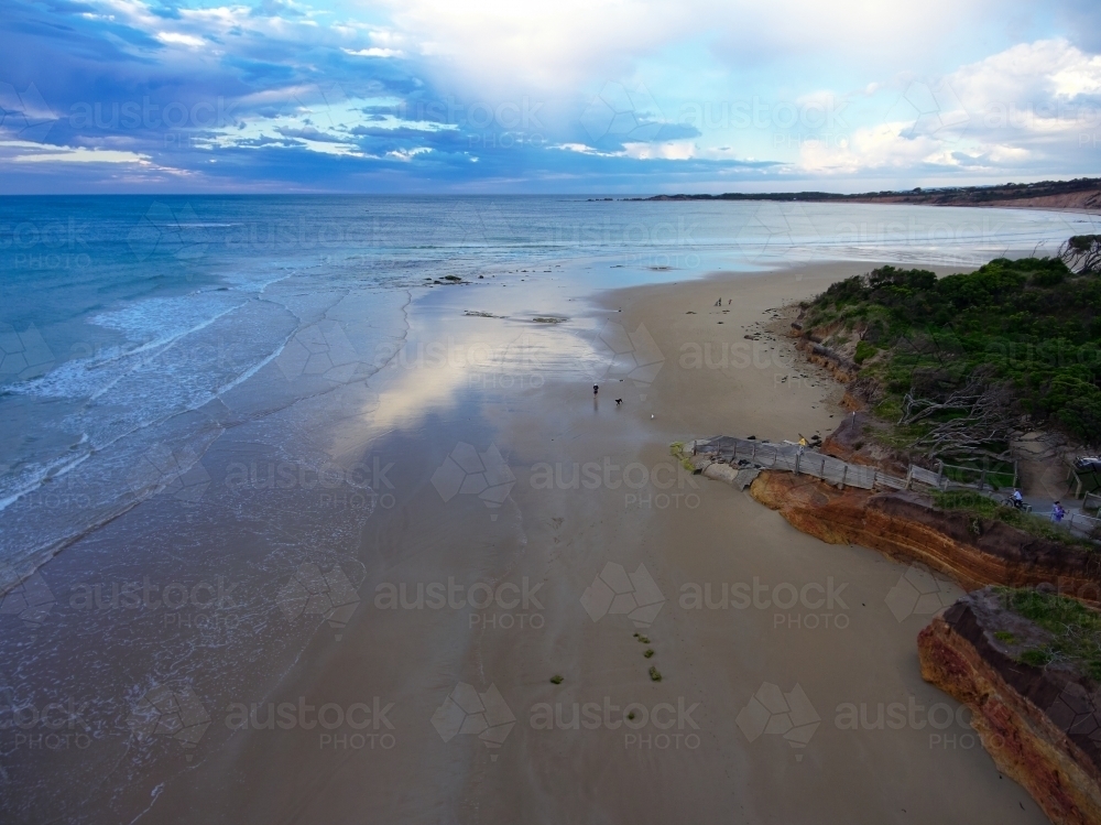 Image of People walking on Anglesea Beach at Dusk - Austockphoto