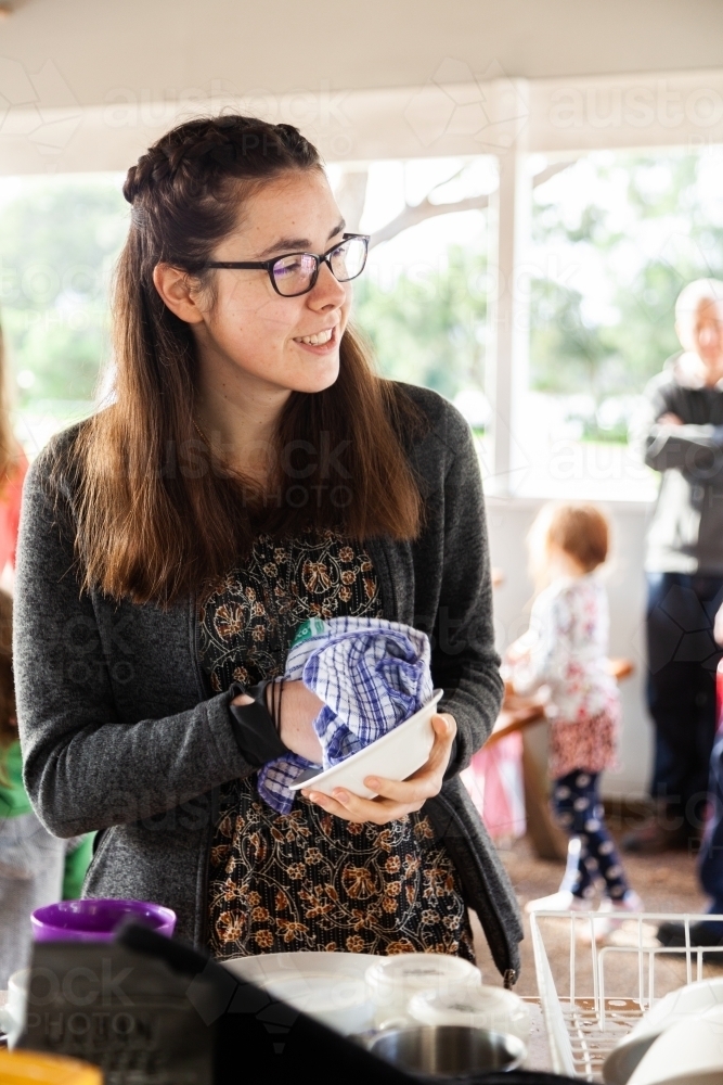 Image of Person drying up dishes beside sink at park campground ...