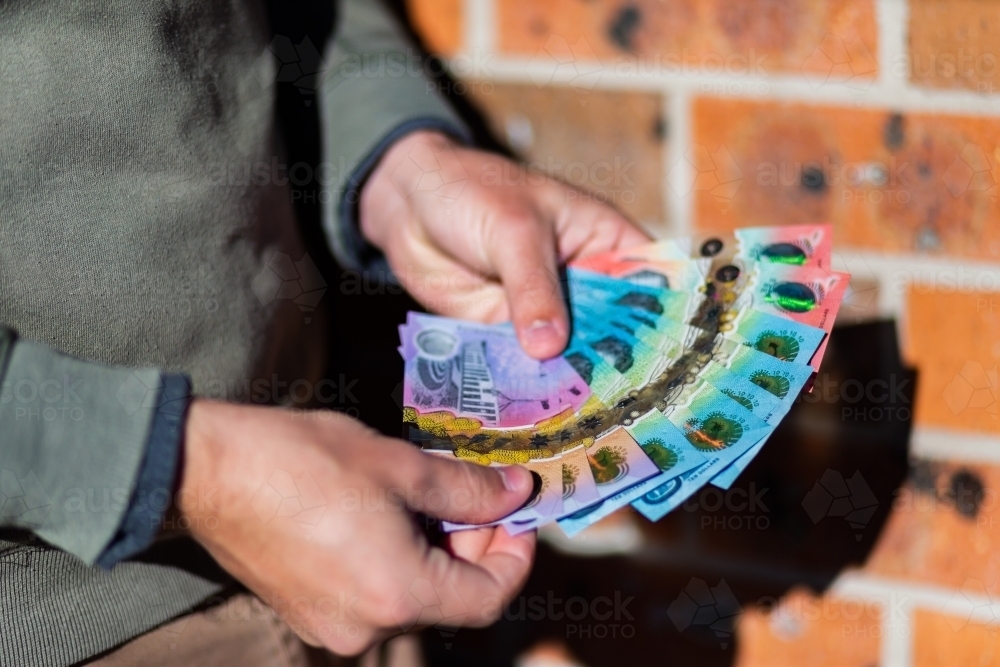 Image of Person fanning out money, new australian cash notes - Austockphoto