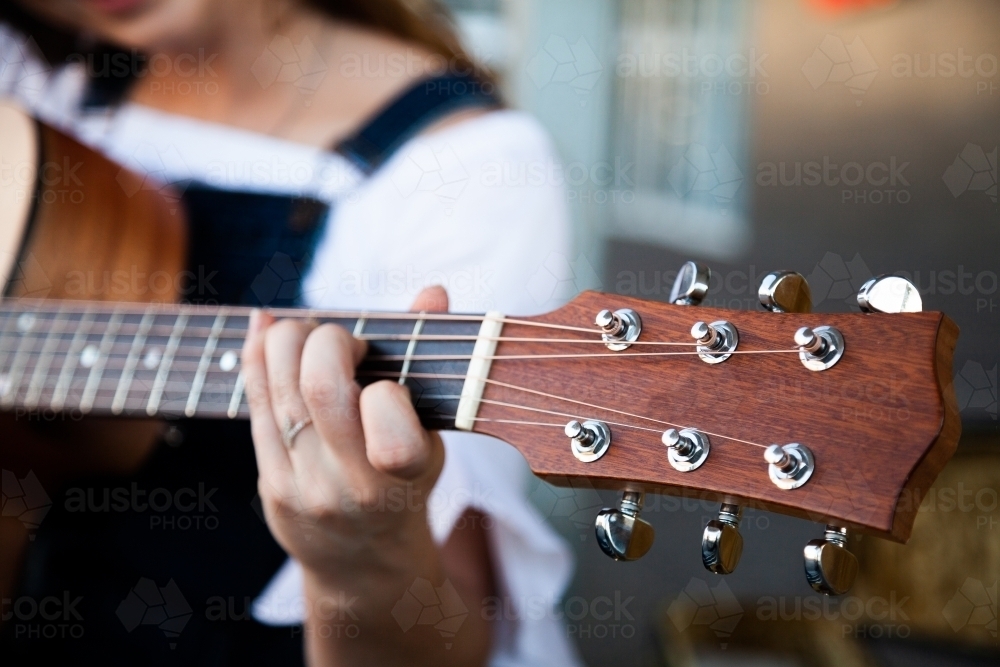 Image of Person playing chords on a guitar - Austockphoto