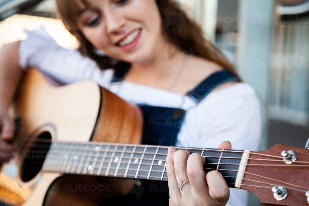 Image of Person playing chords on a guitar - Austockphoto