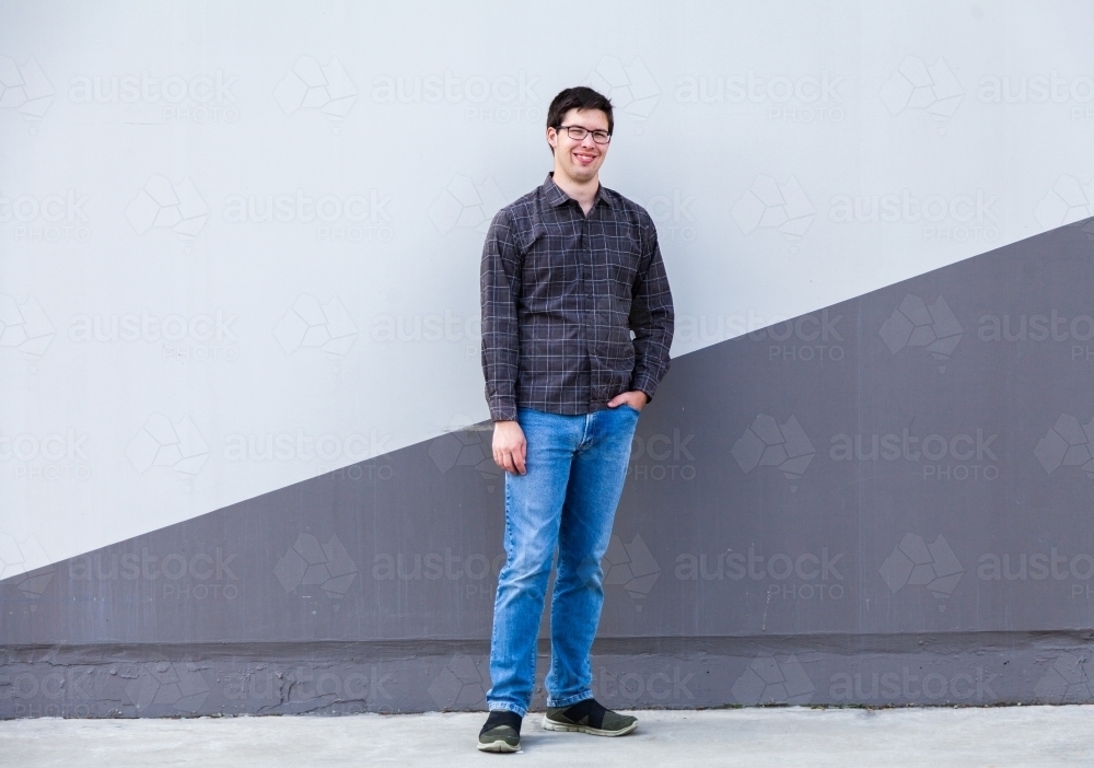 Image of Person standing beside wall in urban area - full length body ...