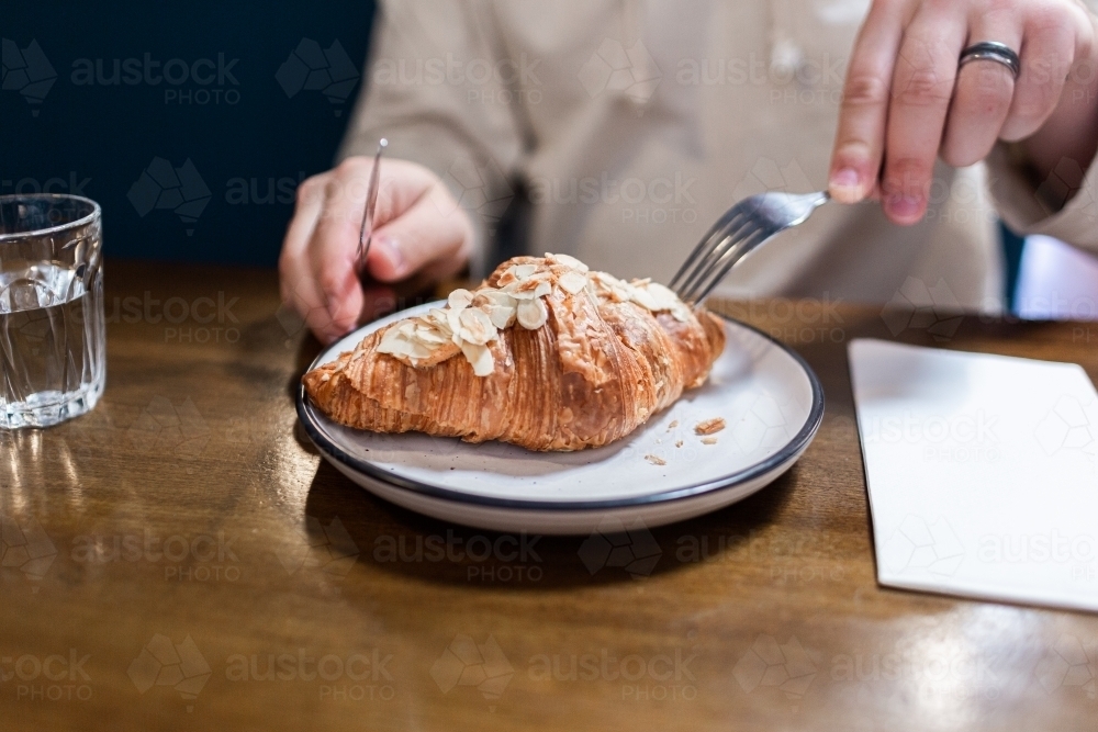 Image of Person using cutlery to eat pastry snack food at café ...