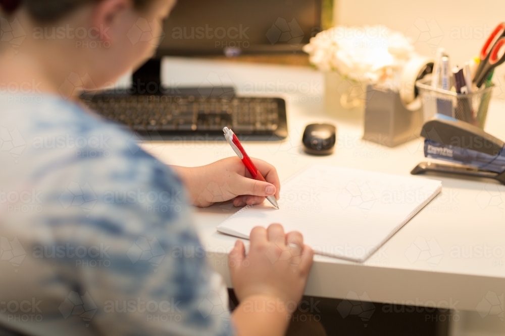 Image of Person writing notes with pen at a desk - Austockphoto