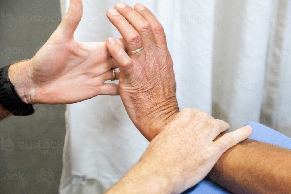 Image of Physio checking wrist injury - Austockphoto
