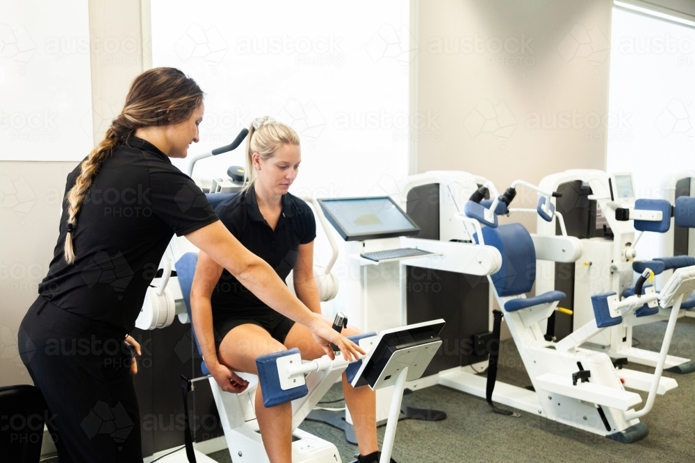 Image of Physio helping client use rehabilitation technology - Austockphoto