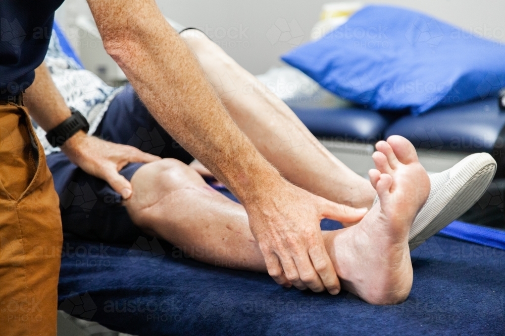 Image of Physiotherapist working to rehabilitate client with leg injury ...