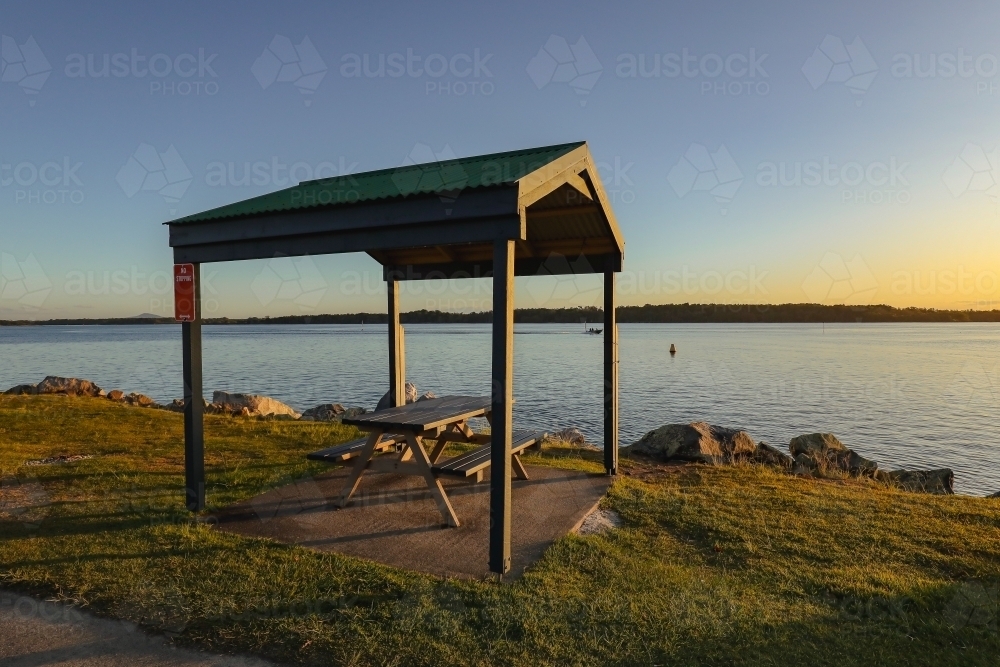 Image of Picnic table with roof on the Clarence River at sunset. Iluka ...
